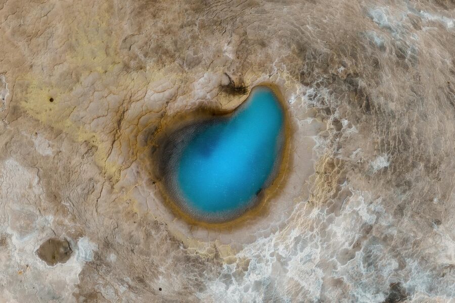 Natural geothermal hot spring pool with bright blue water in Iceland highlands