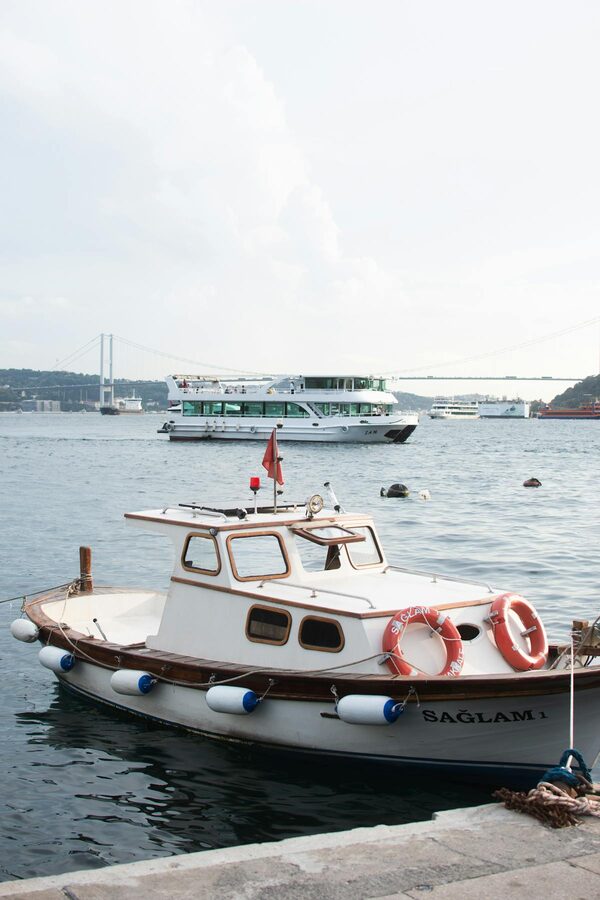 Boats on the Bosphorus with a suspension bridge in the background in Istanbul