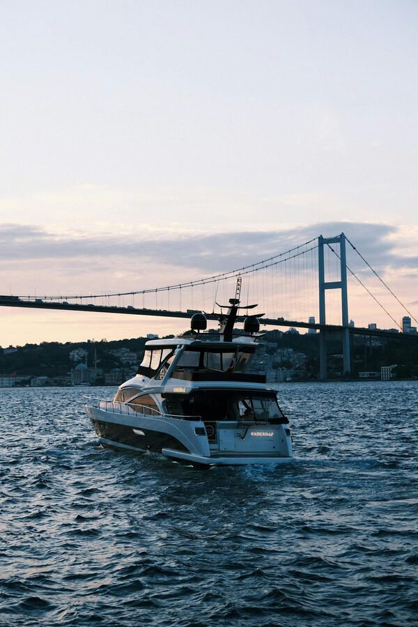 Luxury yacht cruising on the Bosphorus with the suspension bridge in the background
