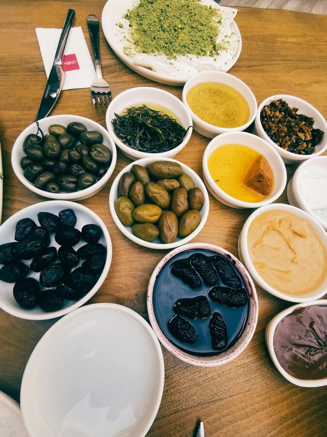 Turkish meze spread with olives dips and breads on a wooden table