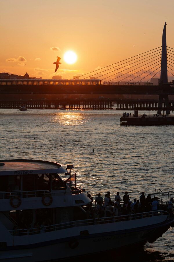 Golden Horn at sunset with ferry and bridge silhouette in Istanbul