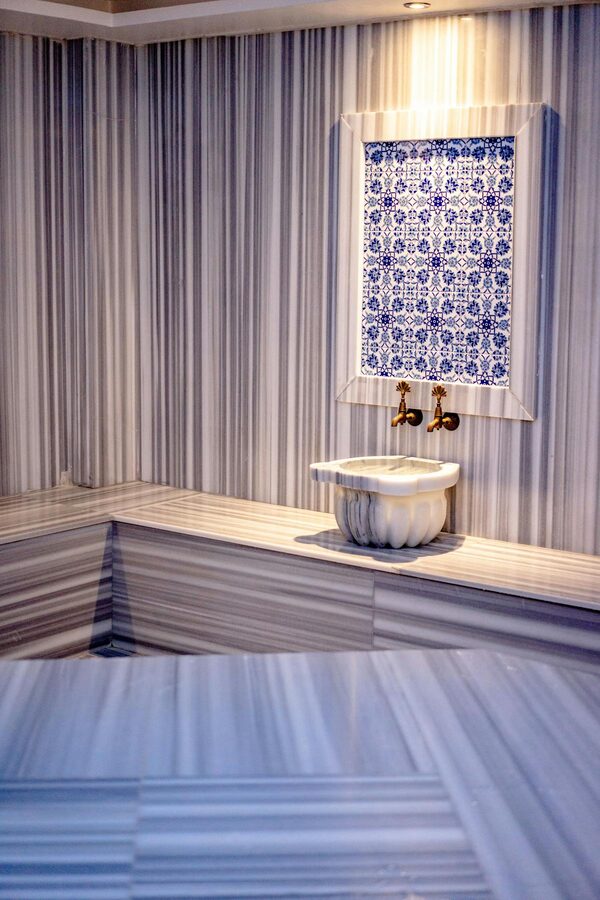 Traditional Turkish hamam interior with marble surfaces and brass faucets