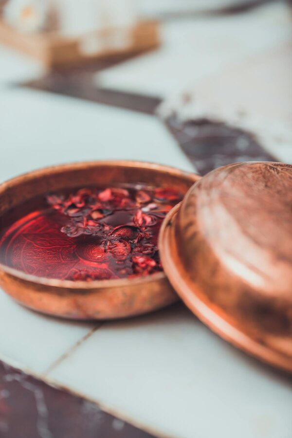 Copper bowl with dried rose petals in water at a Turkish bath