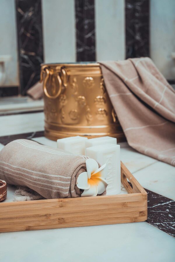 Towels and candles arranged in a serene Turkish bath setting