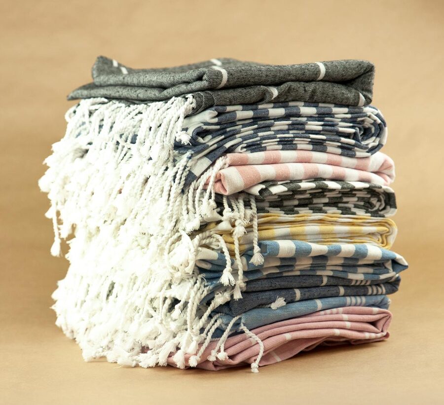 Stack of colourful striped Turkish towels with tassels