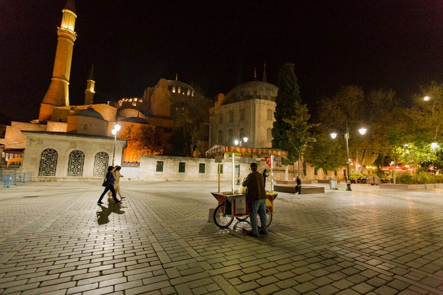 Sultanahmet Square at night with illuminated Hagia Sophia and street vendors