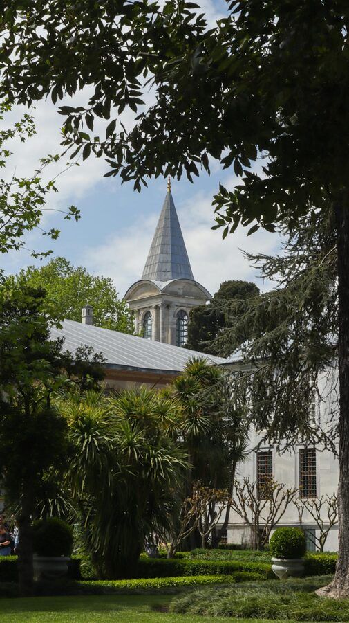 Topkapi Palace tower among trees on a clear day in Istanbul