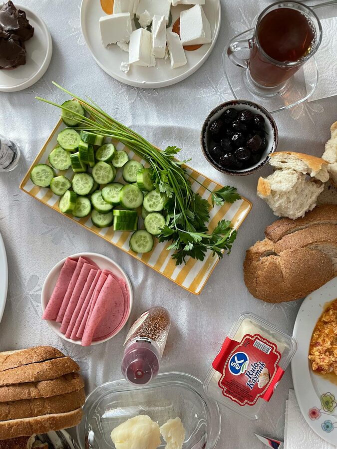 Traditional Turkish breakfast spread with cucumbers, cheese, bread, and tea