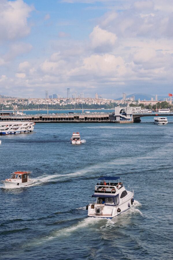 Boats sailing in busy Bosphorus waters with Istanbul city backdrop