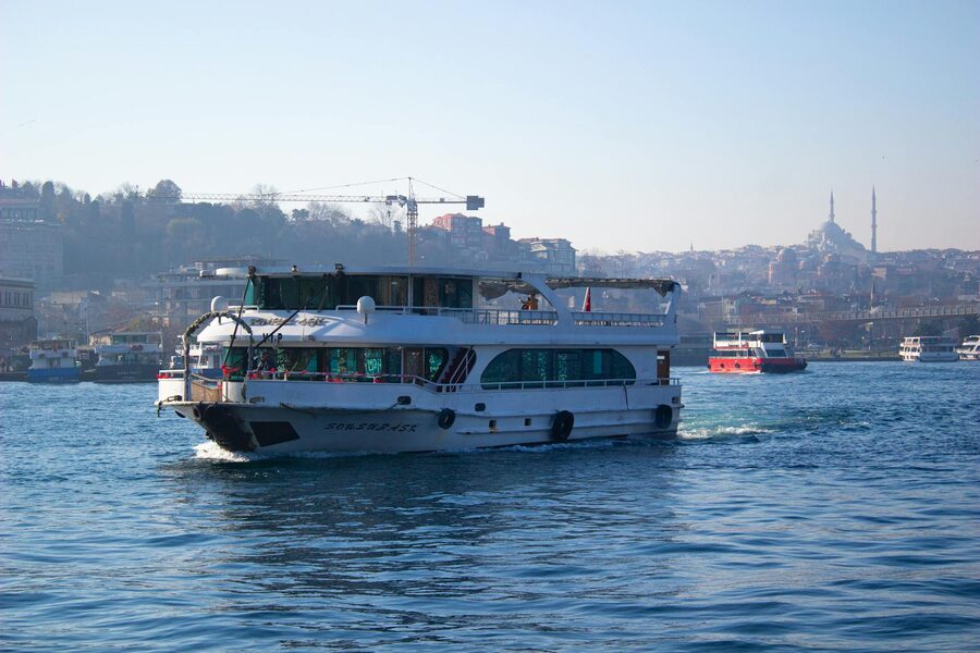 A ferry navigates the Bosphorus with Istanbul skyline and landmarks in the background