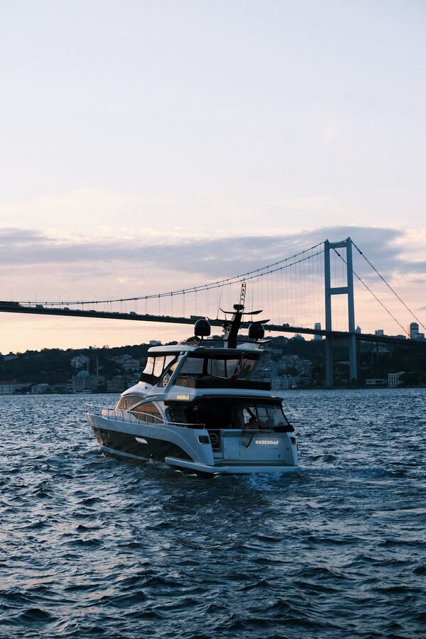 Luxury yacht cruising on the Bosphorus with the bridge at sunset