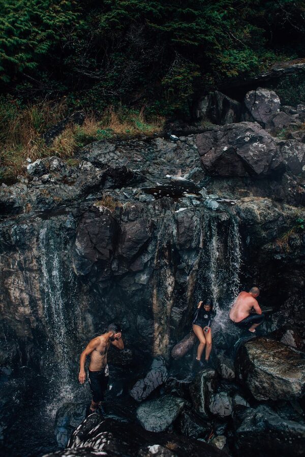 People sitting on rocky riverbank