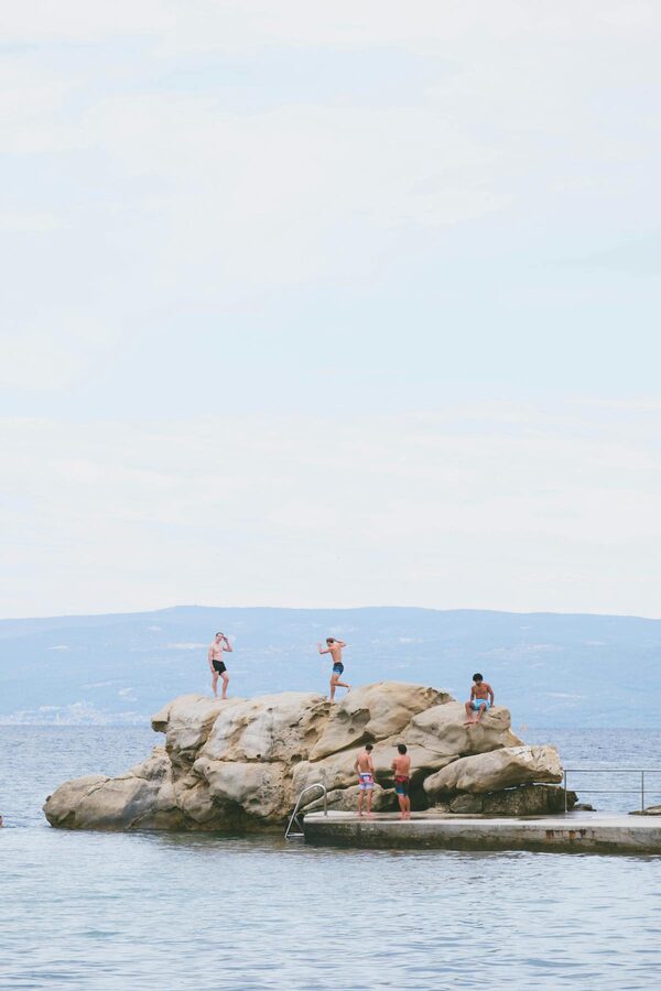 People enjoying sunny day on rocky shore in Split Croatia