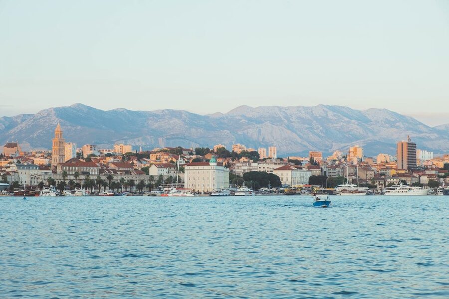 Split cityscape with historic architecture and mountain backdrop
