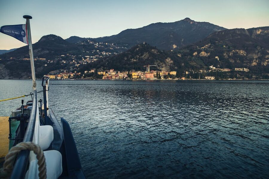 Boat on Lake Como with mountain village at sunset