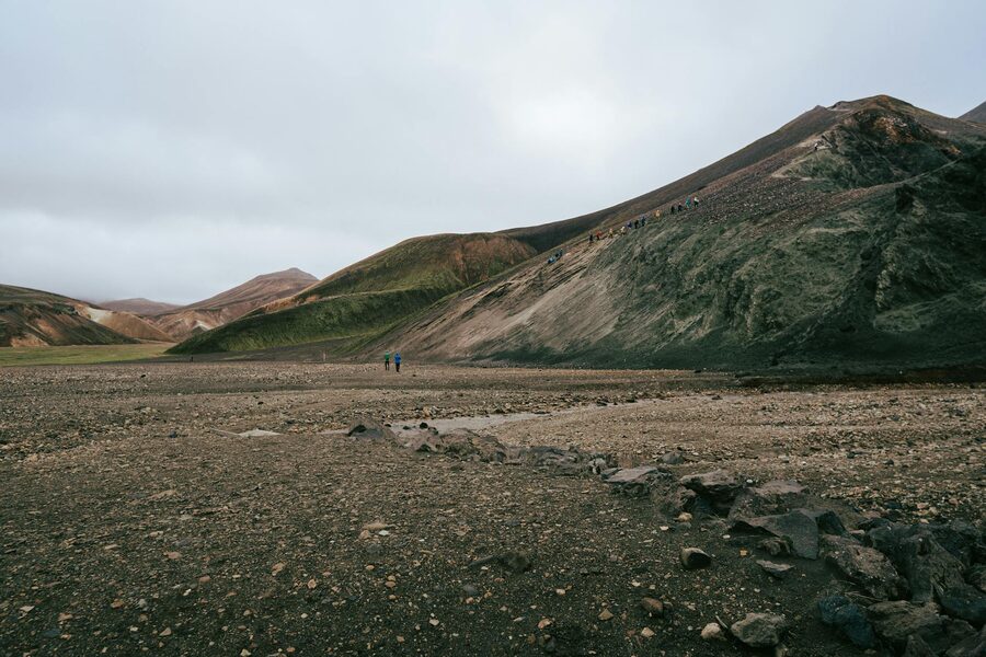 Group of hikers walking through colorful Landmannalaugar mountains