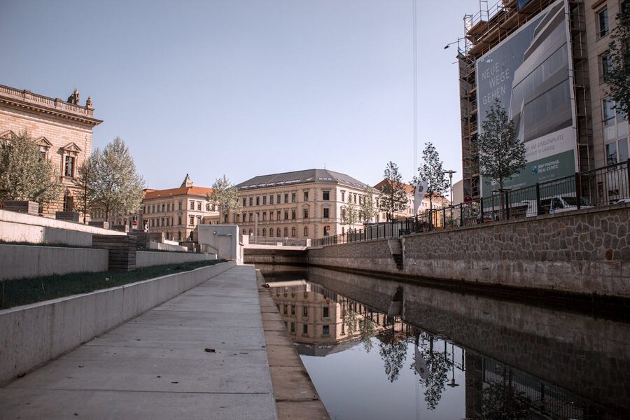 Leipzig architecture reflected in calm canal water on a clear day