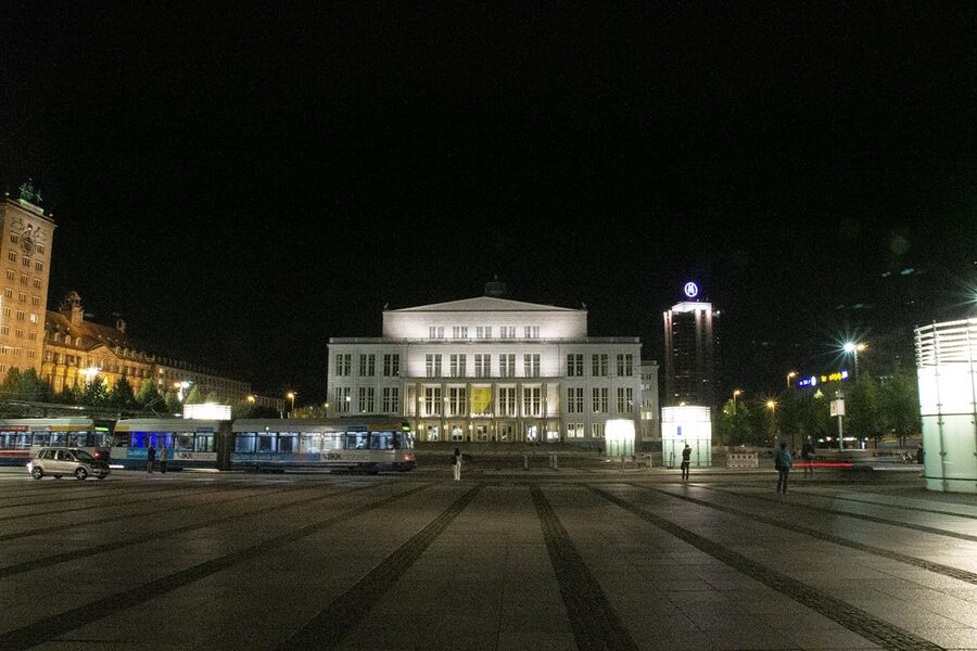 Leipzig Opera House illuminated at night with surrounding cityscape