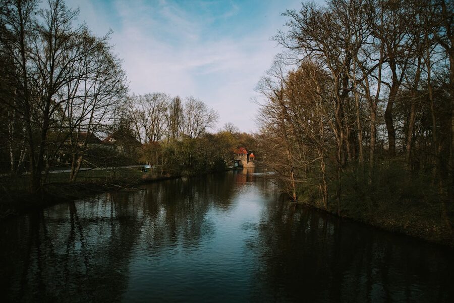 River bank in Leipzig with lush trees and dramatic cloudy sky