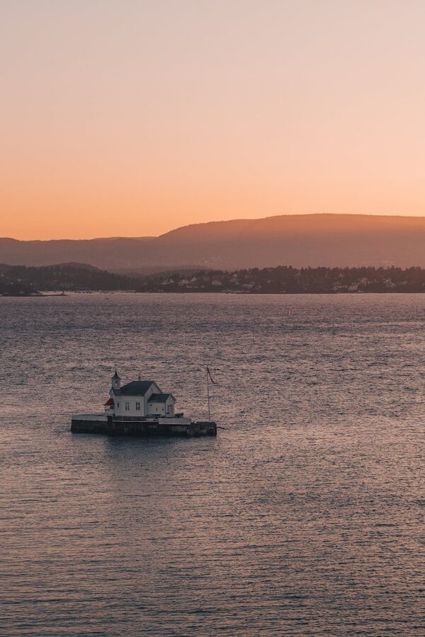 Lighthouse at sunset on Oslo fjord with distant hills