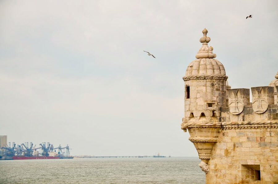 Belem Tower on the Tagus River in Lisbon with birds in flight