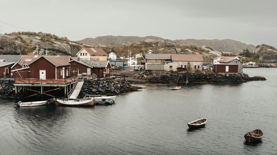 Lofoten fishing village with boats in the harbour and mountains behind
