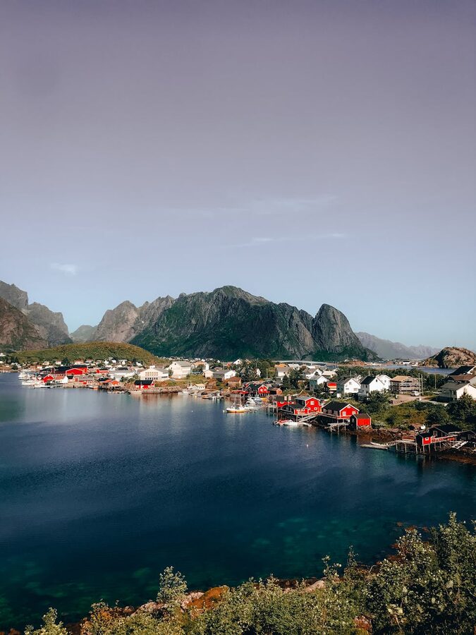 Reine fishing village with dramatic mountain peaks behind red cabins