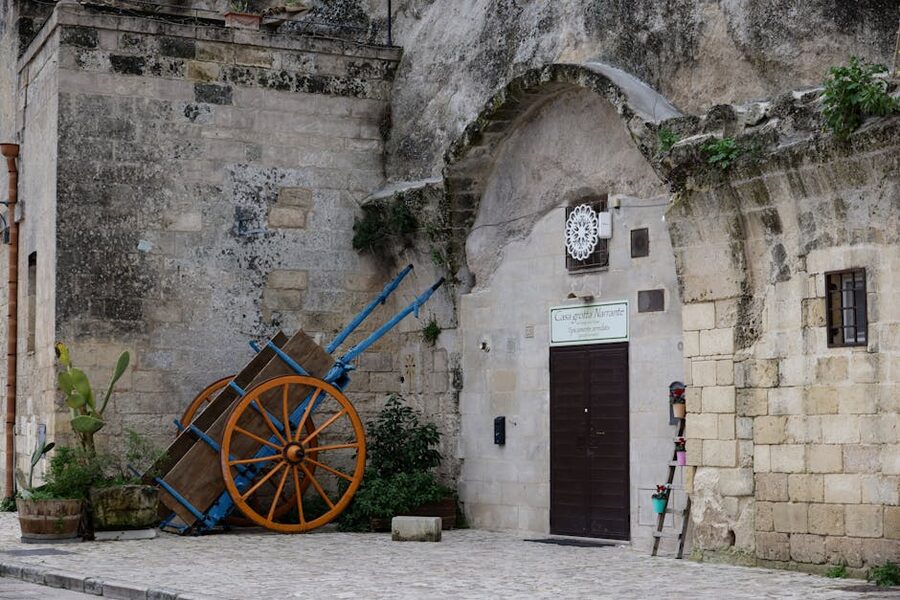 Old stone building with cart and doorway in Matera