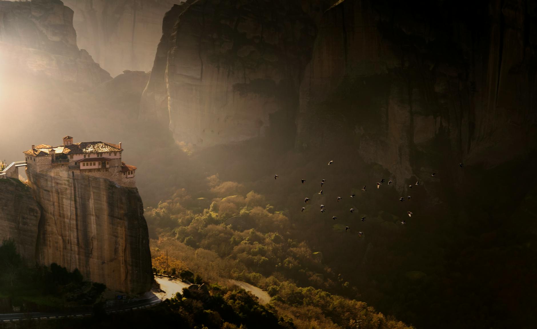 Meteora monastery perched on a cliff at sunset