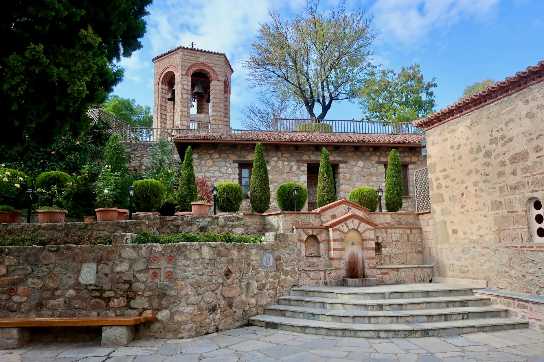 Courtyard of a Meteora monastery with stone walls and arches