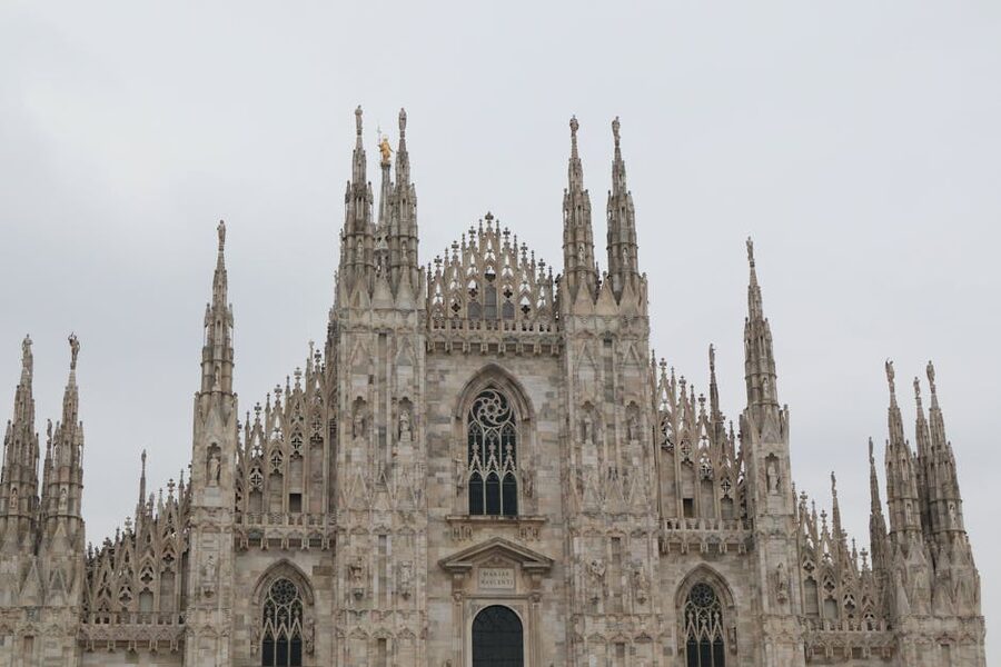 Milan Cathedral facade under cloudy sky