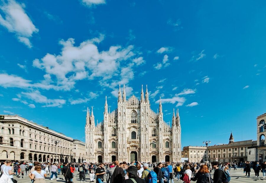 Milan Duomo square with crowd on sunny day in Lombardy