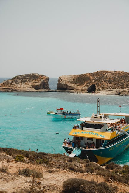 Tour boats and swimmers seen from above at the Blue Lagoon, Comino