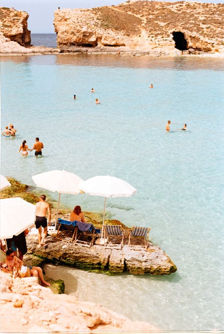Tourists swimming in the Blue Lagoon with boats anchored nearby