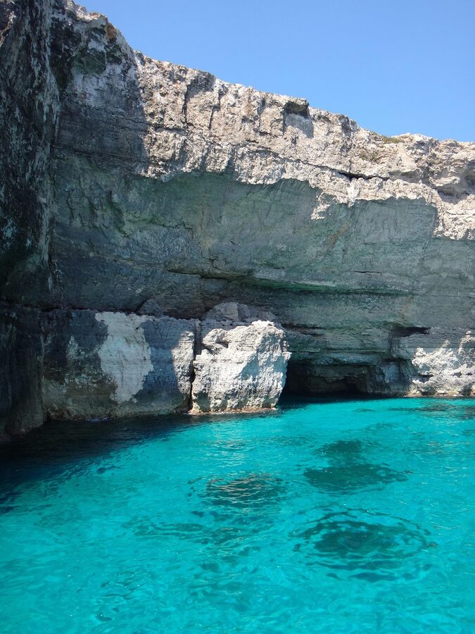 Comino island rocky coastline with Mediterranean blue-green water