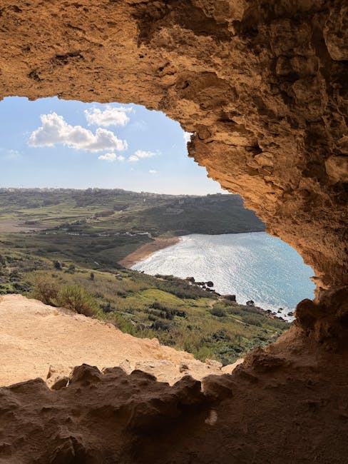 View of Gozo's coastline through a natural cave opening showing blue sea beyond