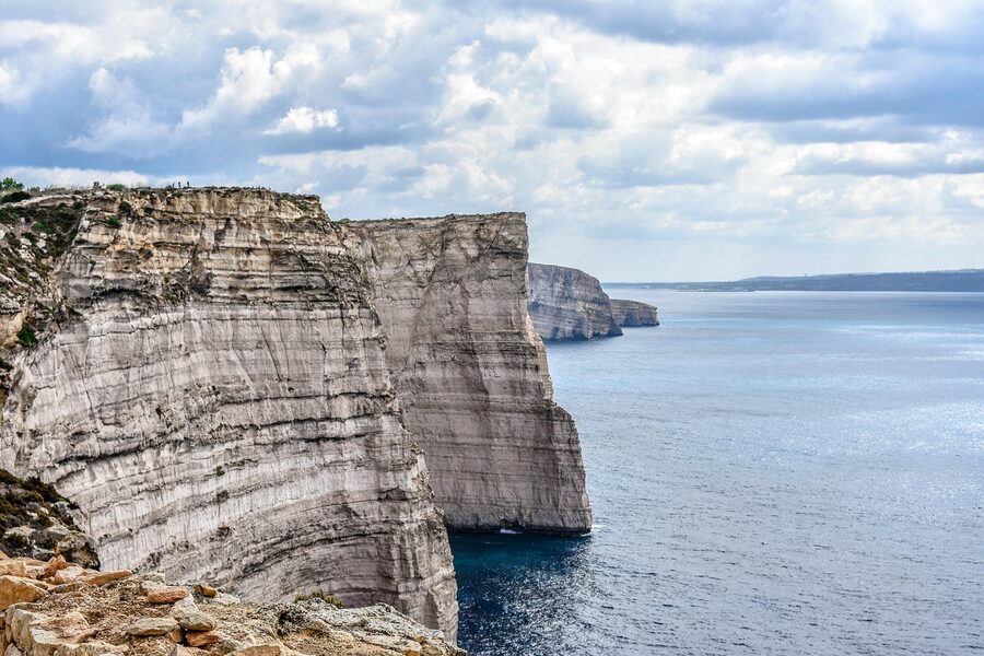 Gozo cliff face with scrub vegetation and Mediterranean blue sea below