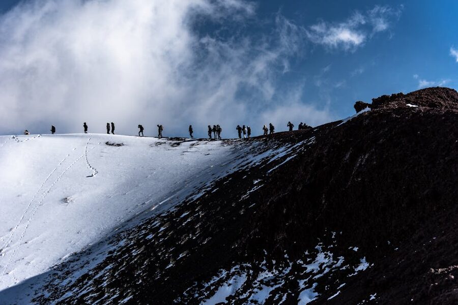 Adventurers trekking snowy Mount Etna