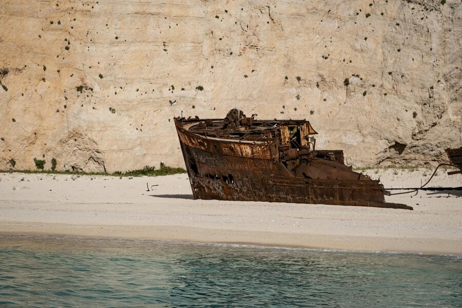 Rusty shipwreck rests on the sandy beach at Navagio, Zakynthos