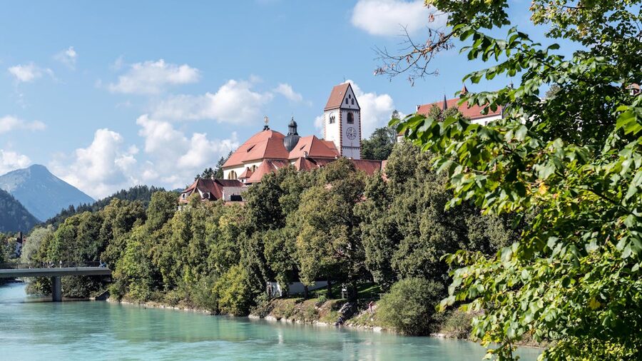 Saint Mang Monastery in Füssen Bavaria framed by trees and river