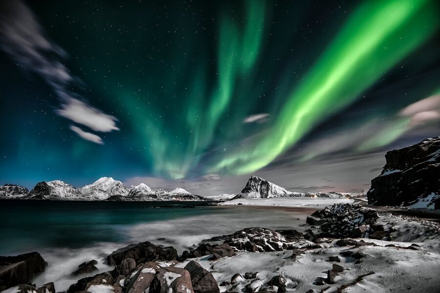 Aurora borealis green glow over Arctic fjord