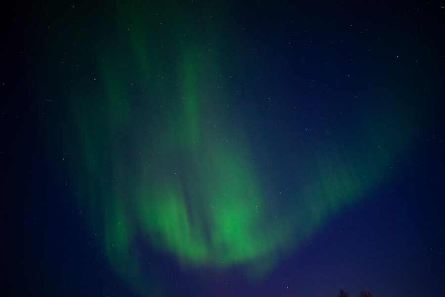 Aurora borealis over snowy Arctic landscape