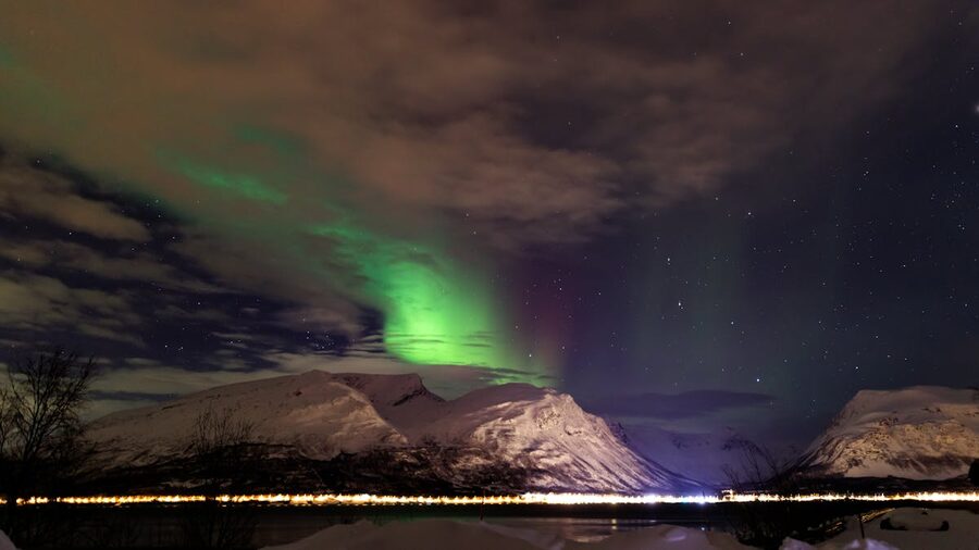 Northern Lights green glow over mountains and water