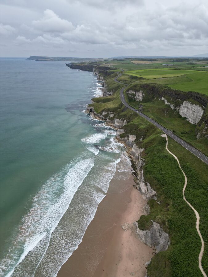 Aerial view of Northern Ireland coastline with green hills and sea