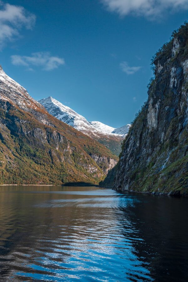Norwegian fjord with towering cliffs reflected in still water