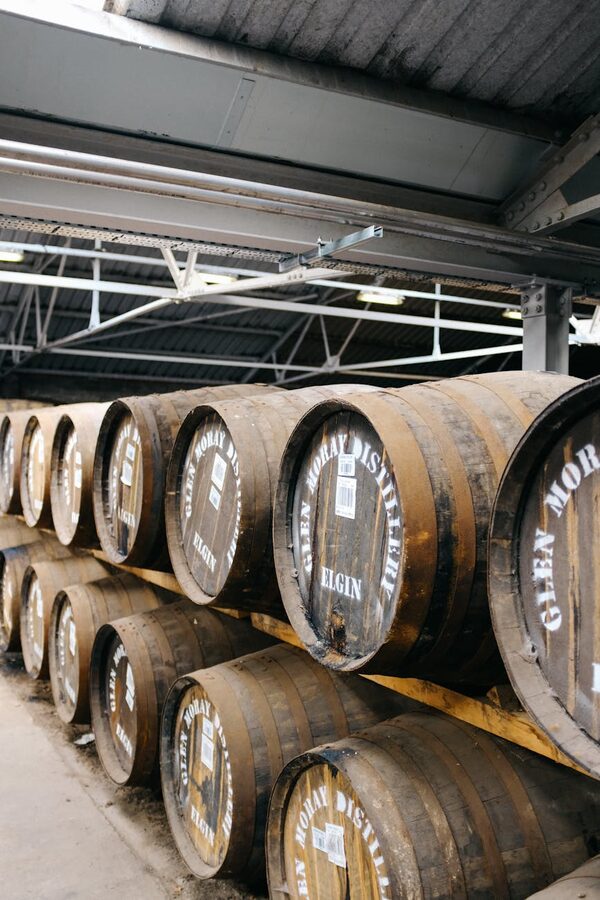 Rows of oak whiskey barrels in a distillery ageing warehouse