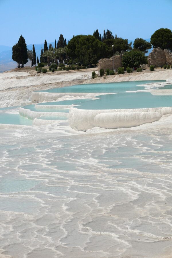 Pamukkale travertine terraces with green vegetation and turquoise pools