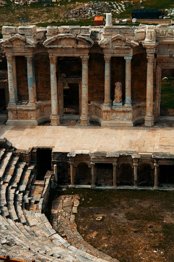 Stone seating rows of the Hierapolis Roman theater with mountain views behind