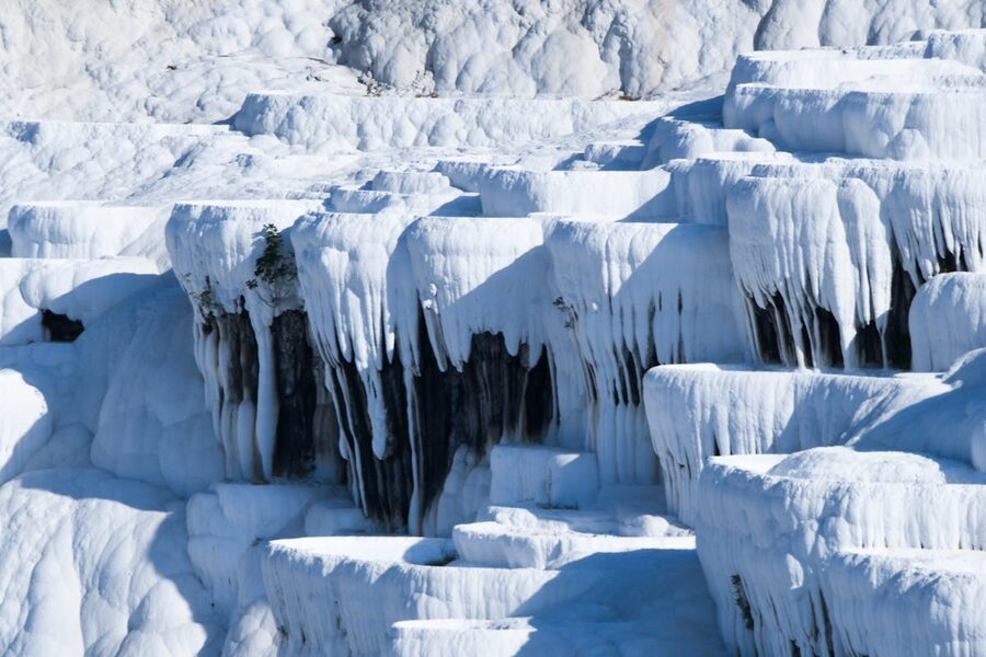 Cascading mineral-rich water over white limestone formations at Pamukkale