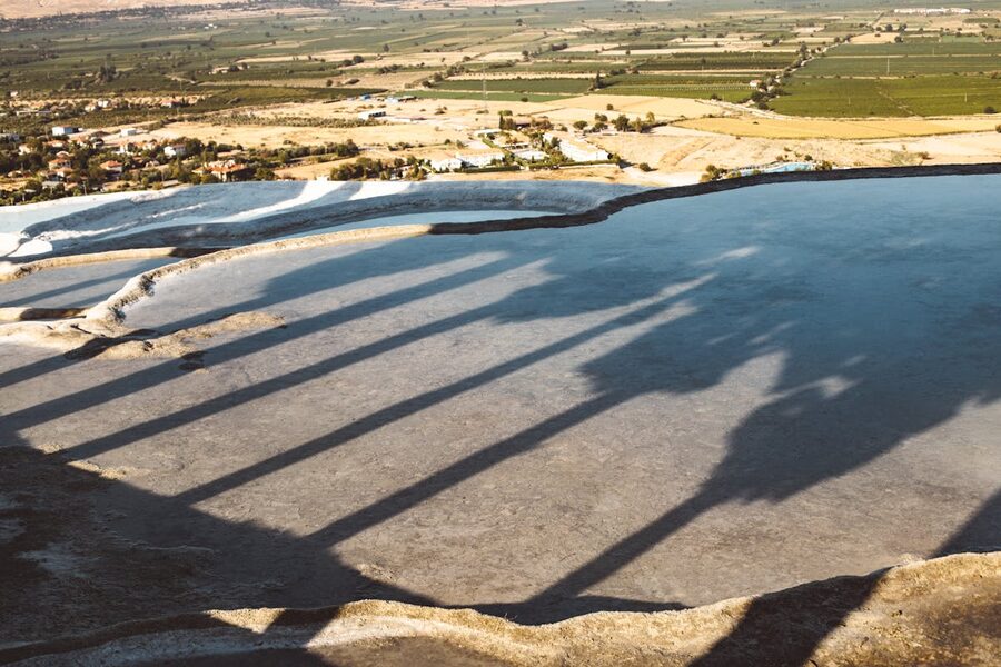 Aerial view of Pamukkale travertine terraces glowing white against green hillside